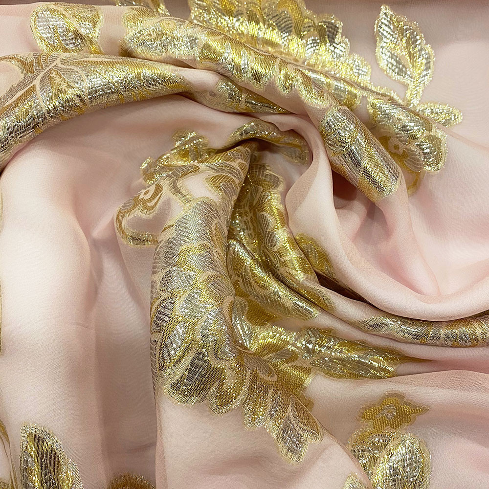 Gold metallic silk jacquard fabric on pale green chiffon background ...